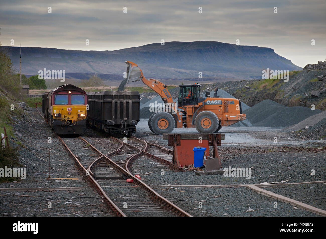 DB Cargo aggregates train being loaded with gritstone in the sidings ...