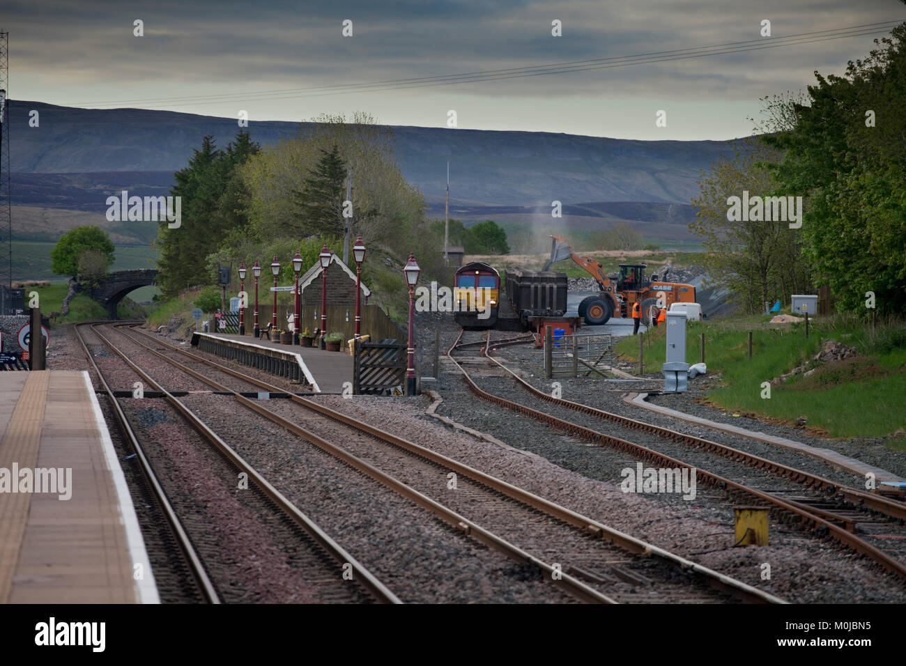 DB Cargo aggregates train being loaded with gritstone in the sidings ...