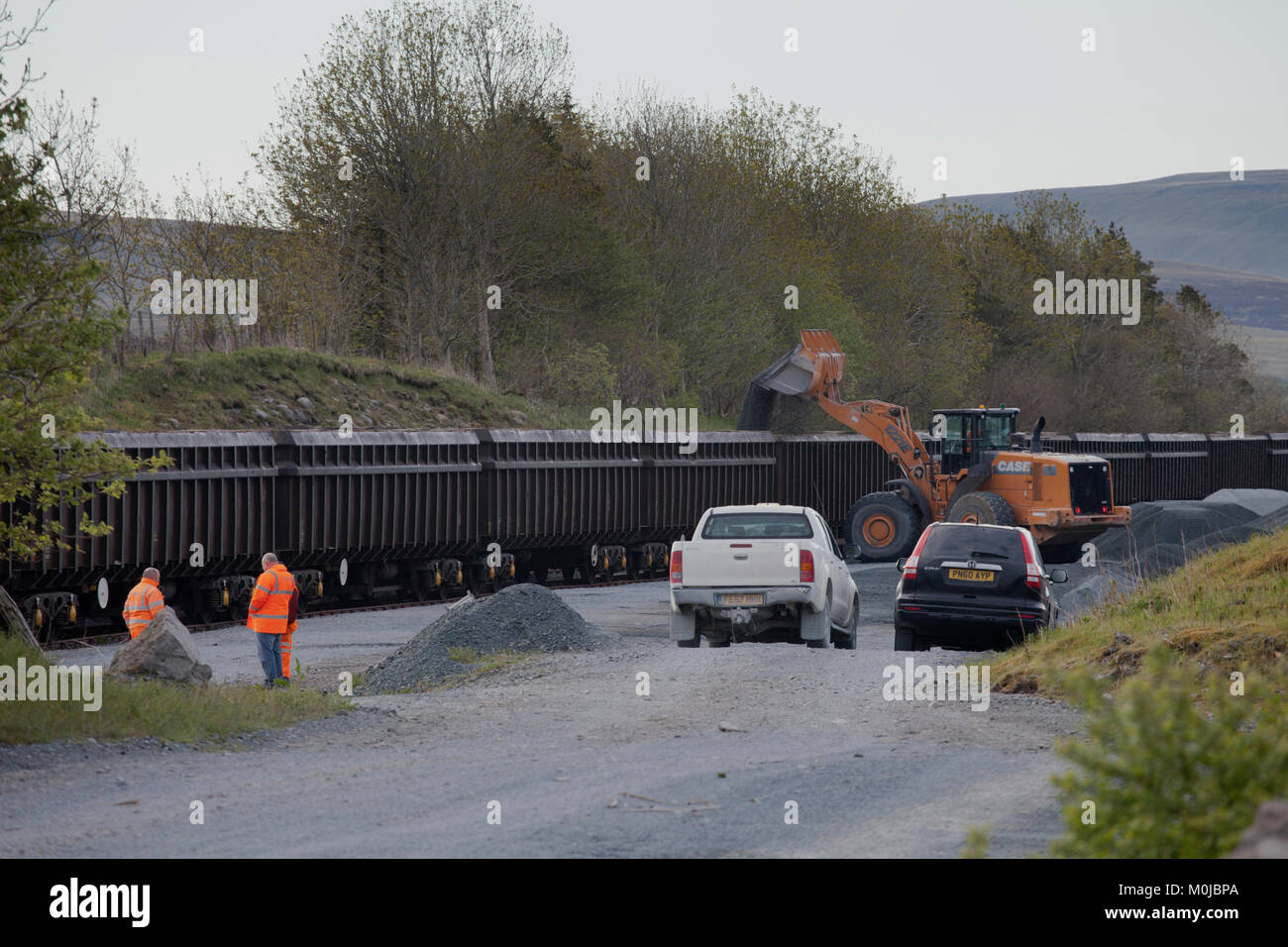 DB Cargo aggregates train being loaded with gritstone in the sidings ...