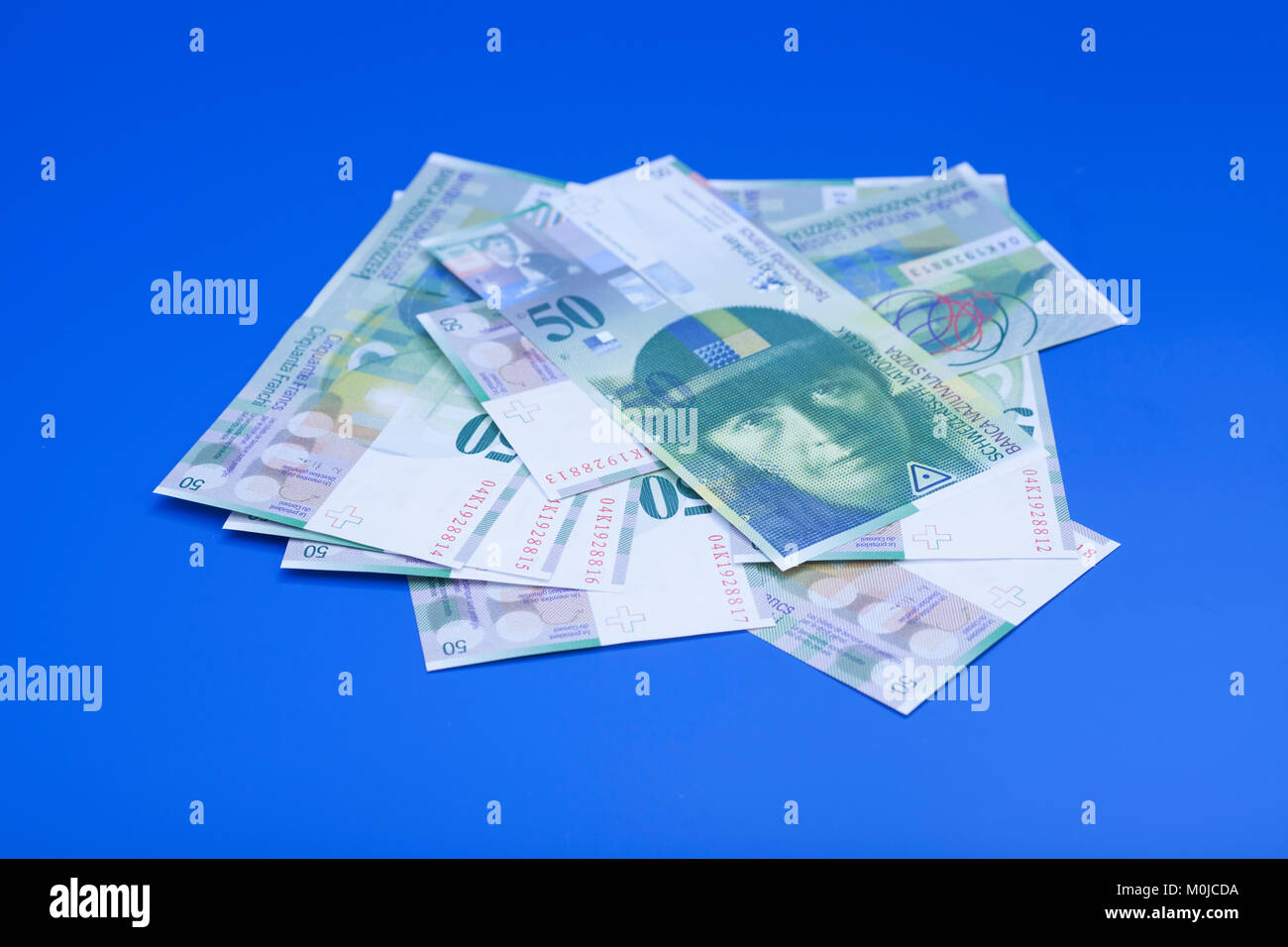 50 Swiss Franc bills on a blue background Stock Photo - Alamy