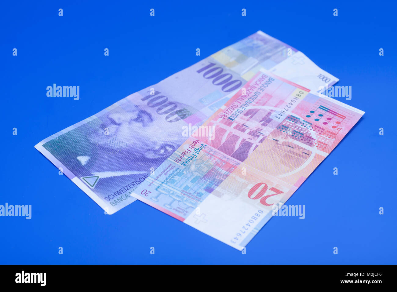 Swiss 1000 and 20 Franc notes on blue Stock Photo - Alamy