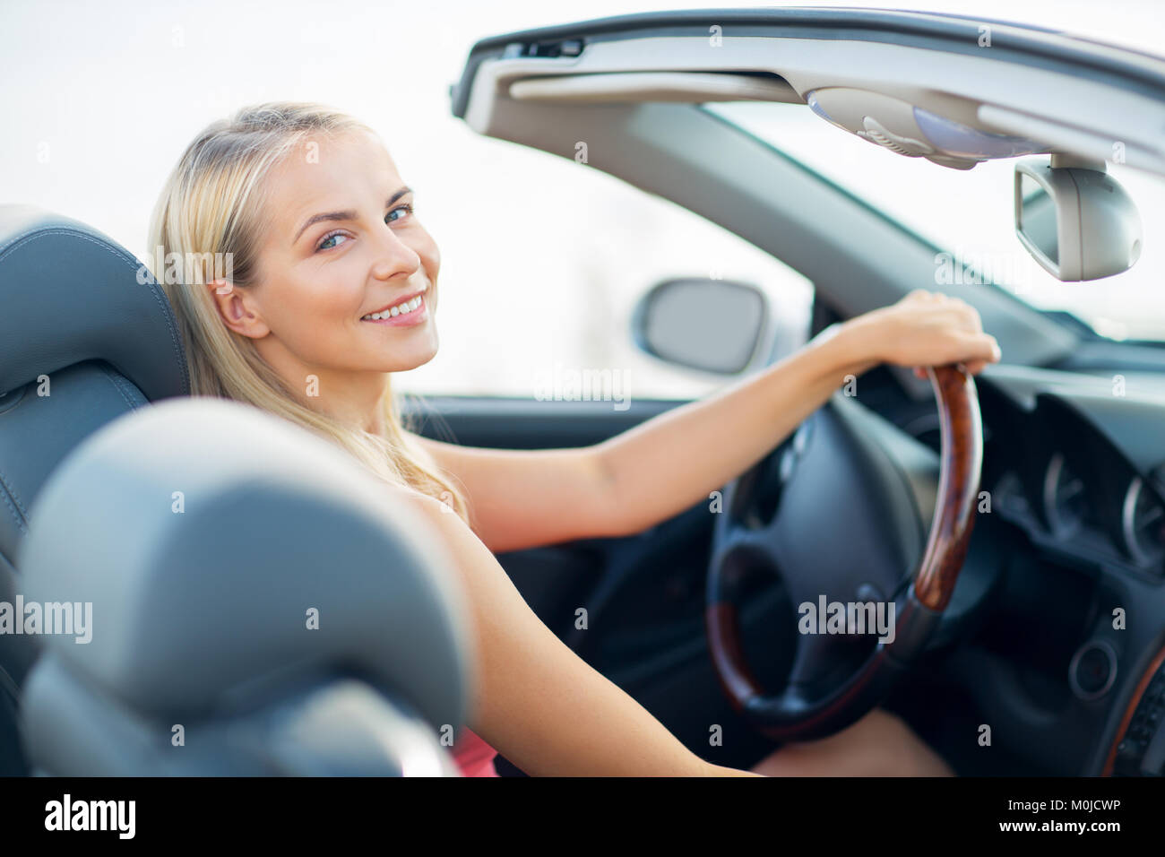 happy young woman driving convertible car Stock Photo - Alamy