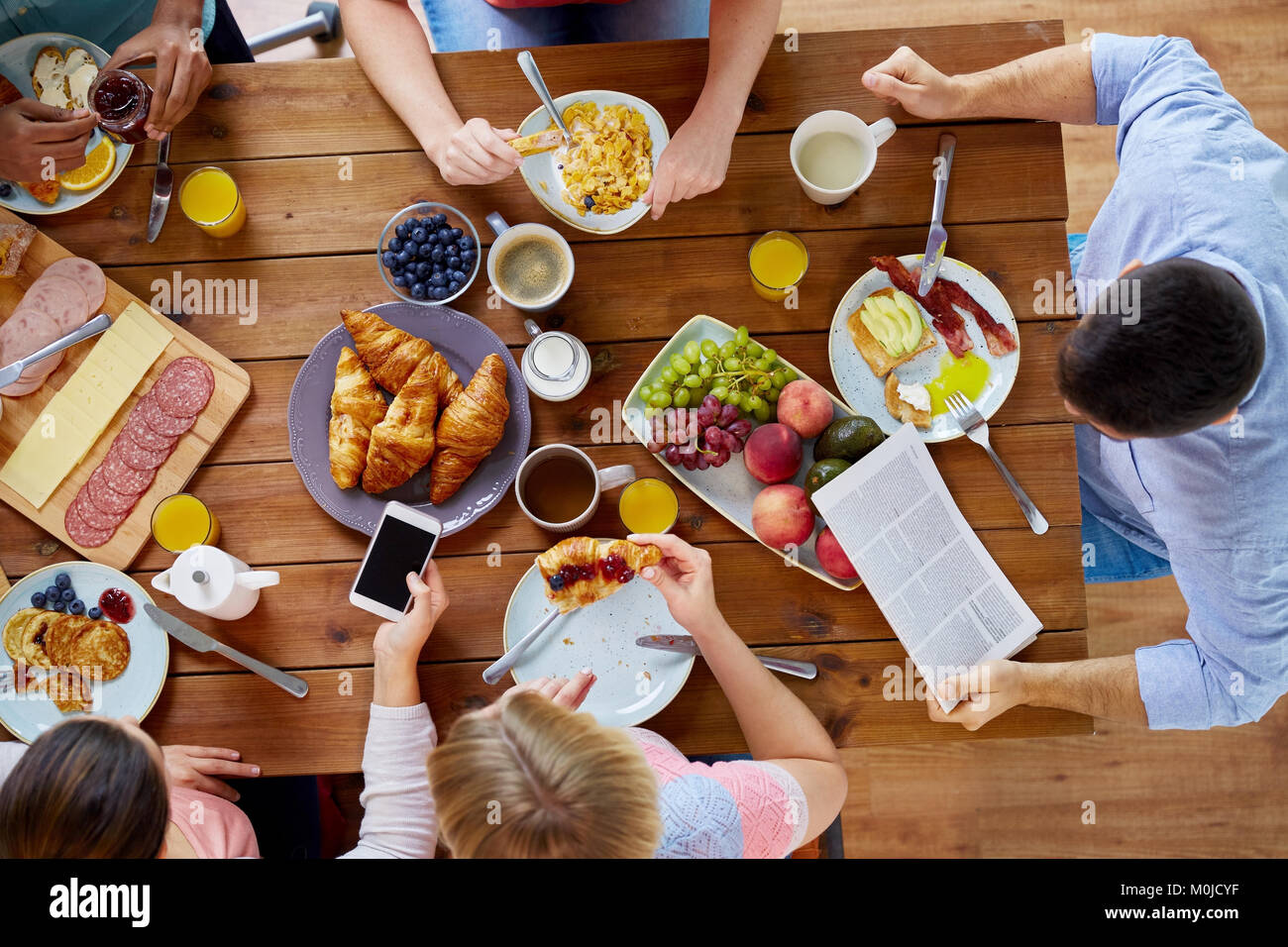 people with smartphones eating food at table Stock Photo - Alamy