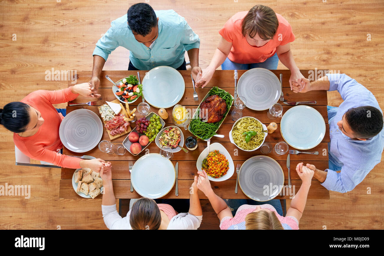 group of people at table praying before meal Stock Photo - Alamy