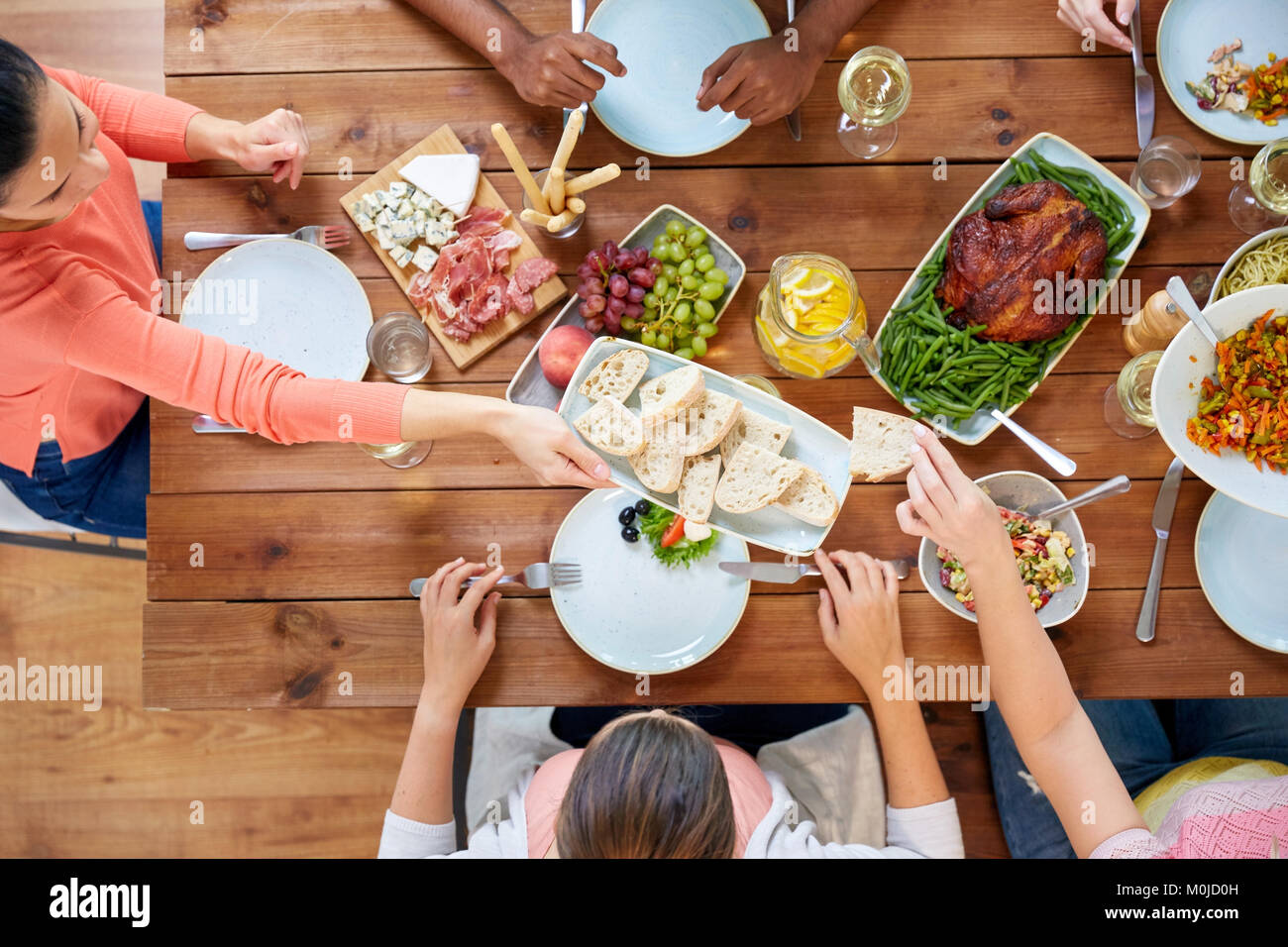 group of people eating at table with food Stock Photo - Alamy