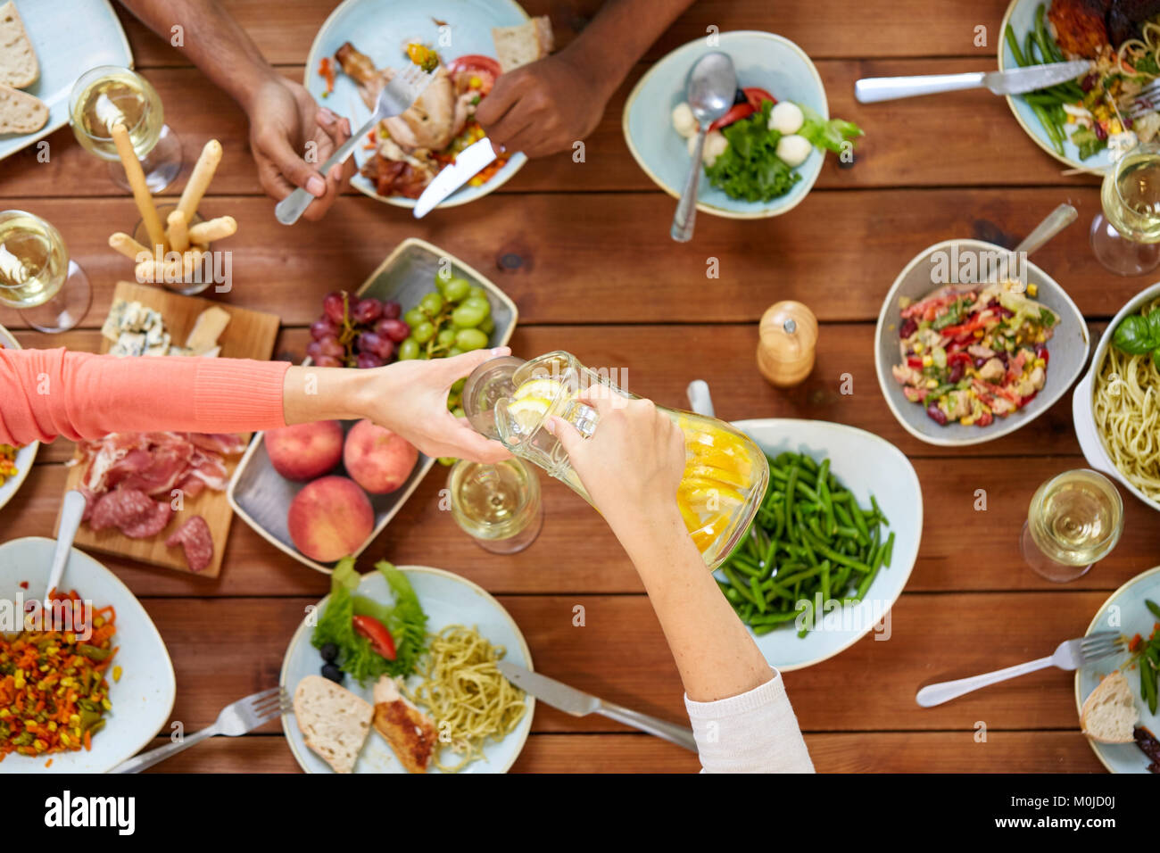 people at table with food eating and drinking Stock Photo - Alamy
