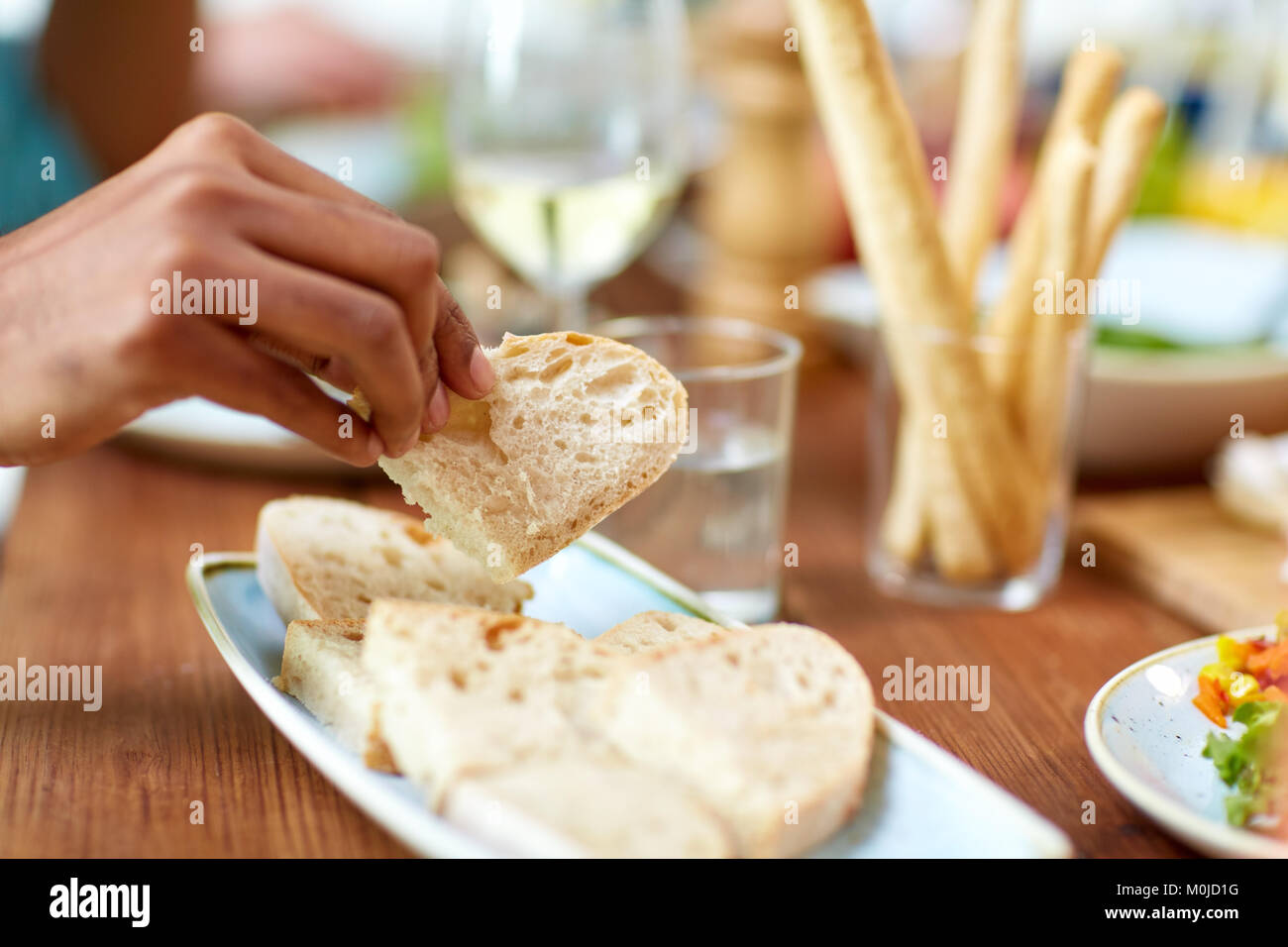 hand taking piece of bread from plate Stock Photo - Alamy