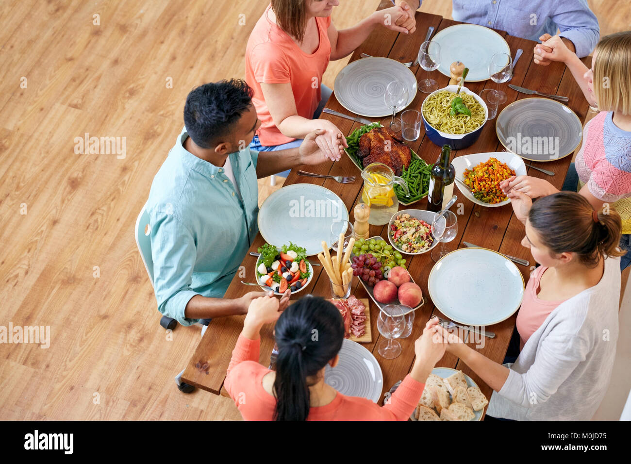 group of people at table praying before meal Stock Photo - Alamy