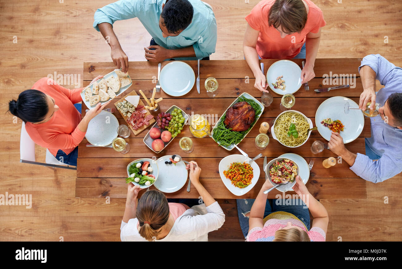 group of people eating at table with food Stock Photo - Alamy