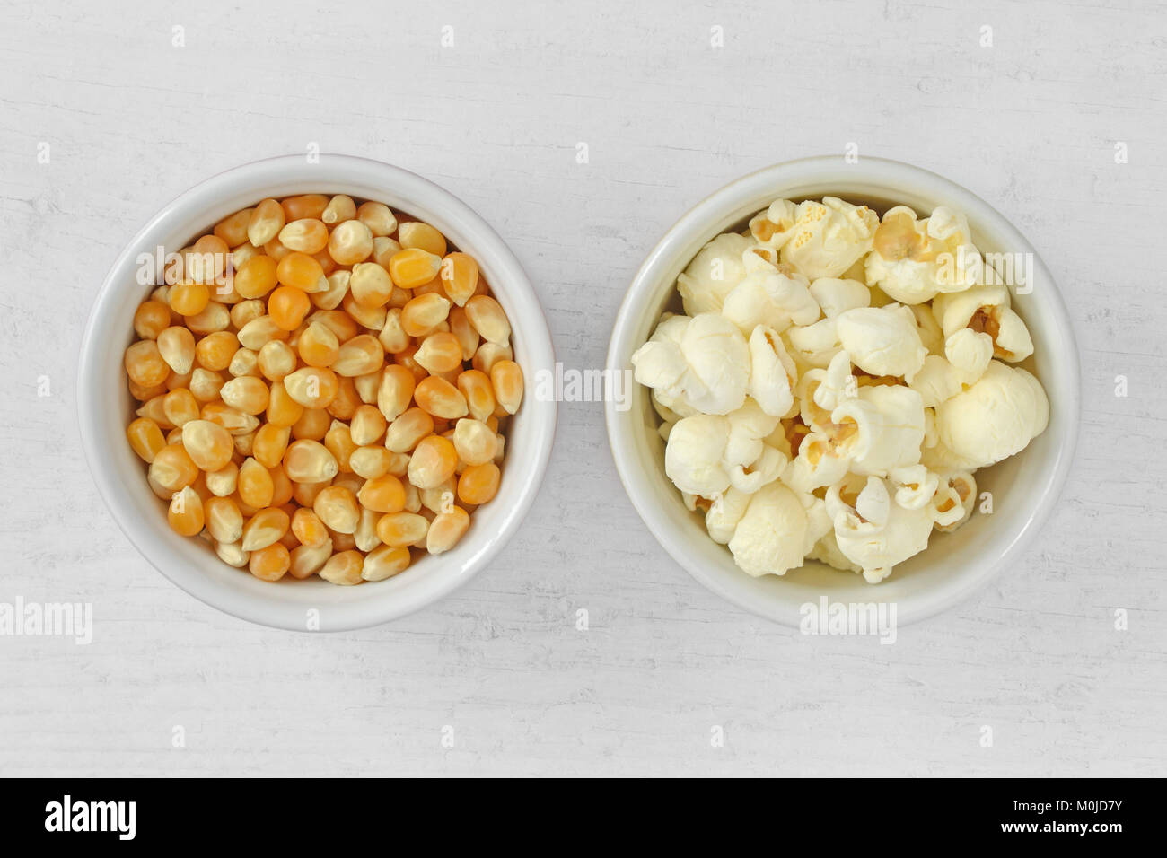 Dried corn kernels and pop corn in bowls on wooden background Stock ...