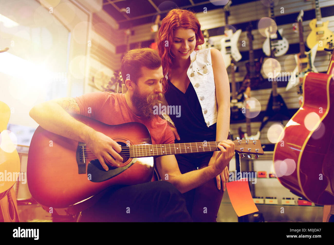 couple of musicians playing guitar at music store Stock Photo - Alamy