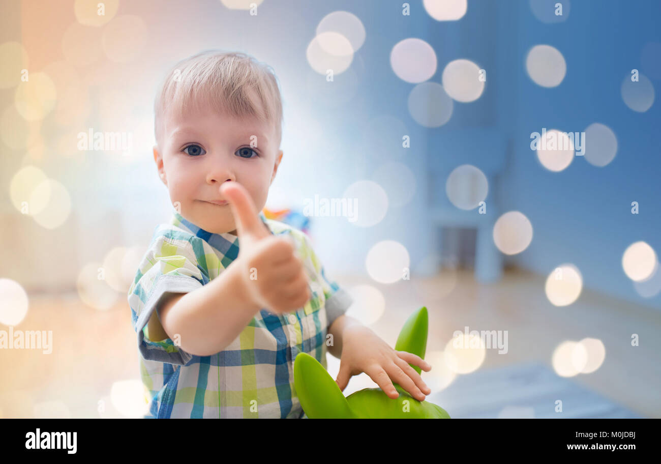 happy baby boy playing with toy showing thumbs up Stock Photo - Alamy