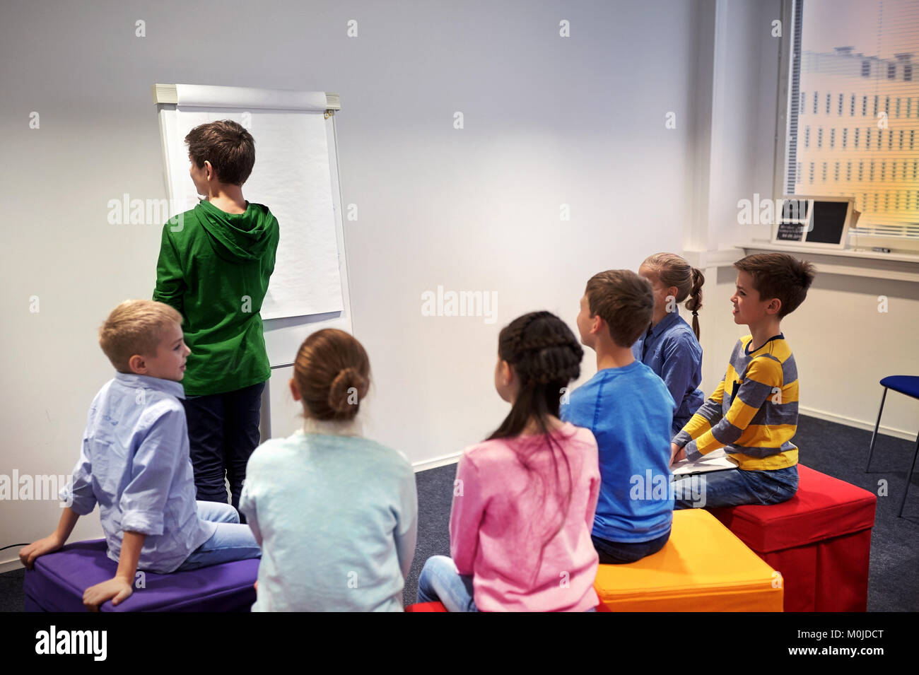 student boy with marker writing on flip board Stock Photo - Alamy
