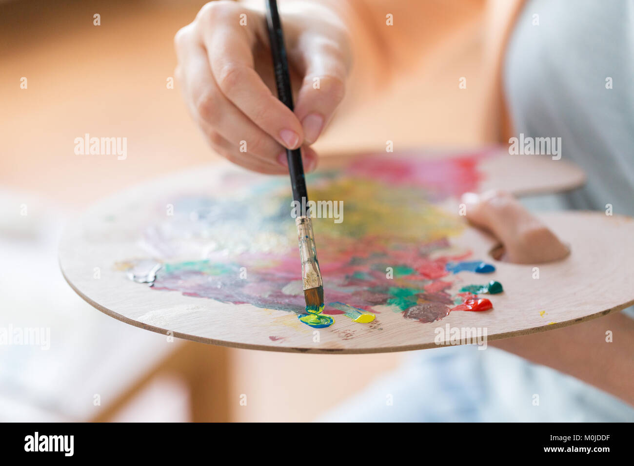 artist with palette and brush painting at studio Stock Photo - Alamy