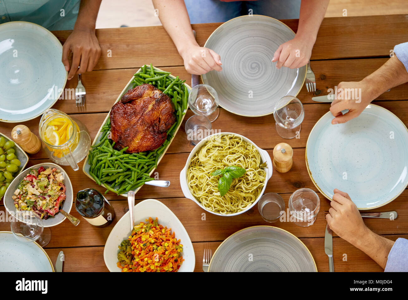 group of people with chicken and pasta on table Stock Photo - Alamy