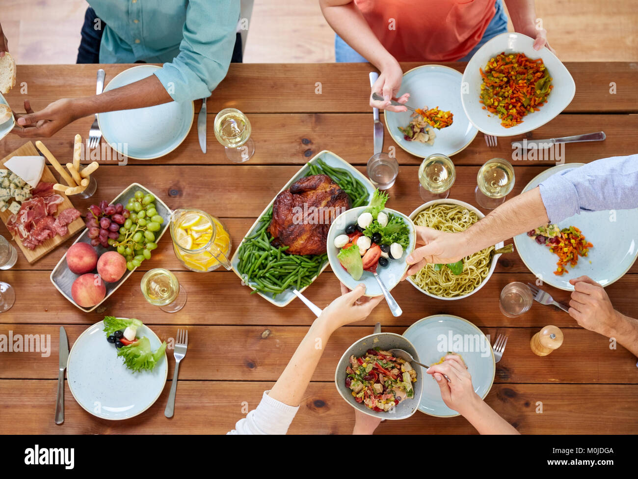 group of people eating at table with food Stock Photo - Alamy