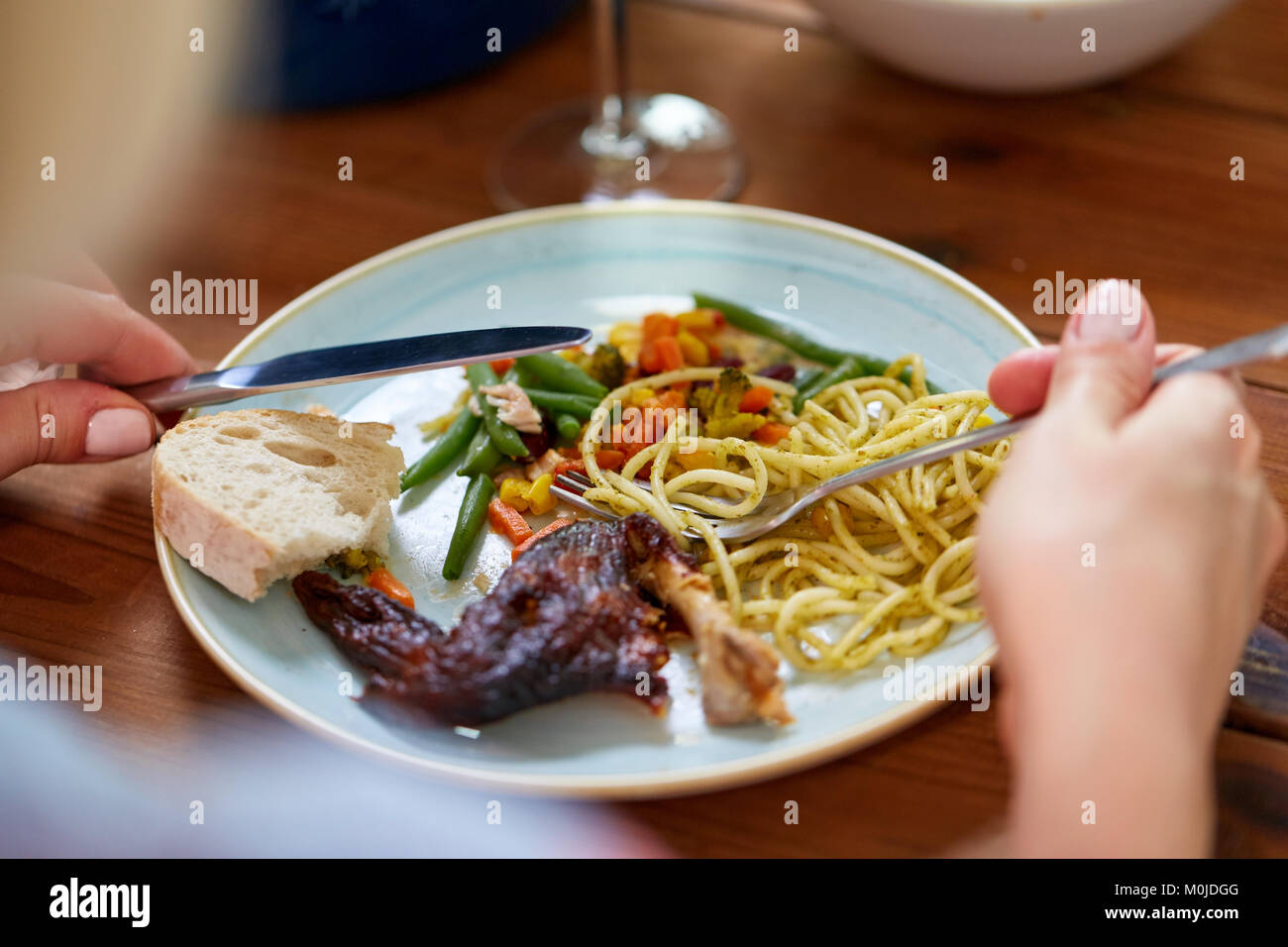 hands of woman eating pasta and roast chicken Stock Photo - Alamy