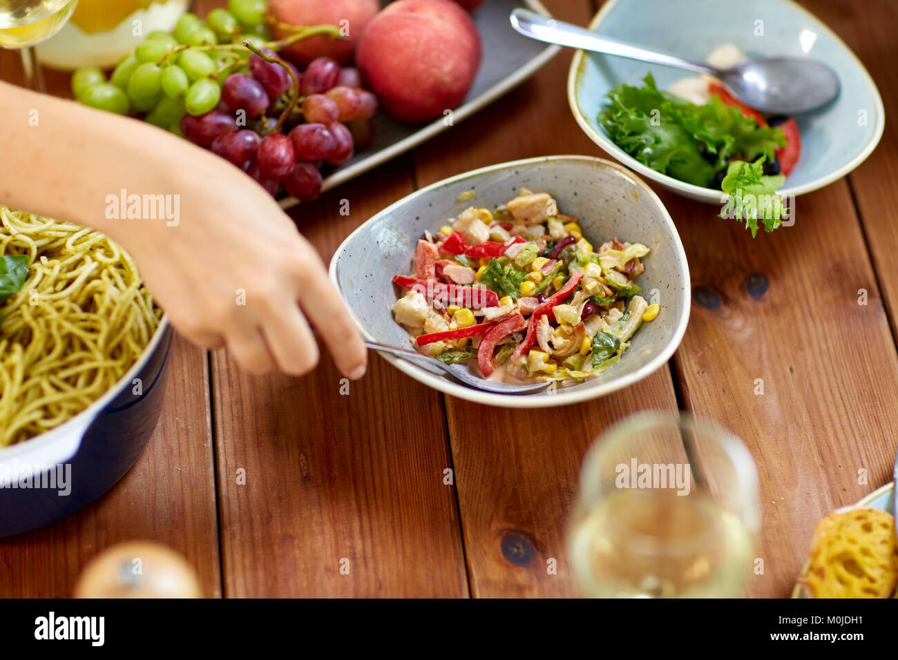 people eating salad at table with food Stock Photo - Alamy