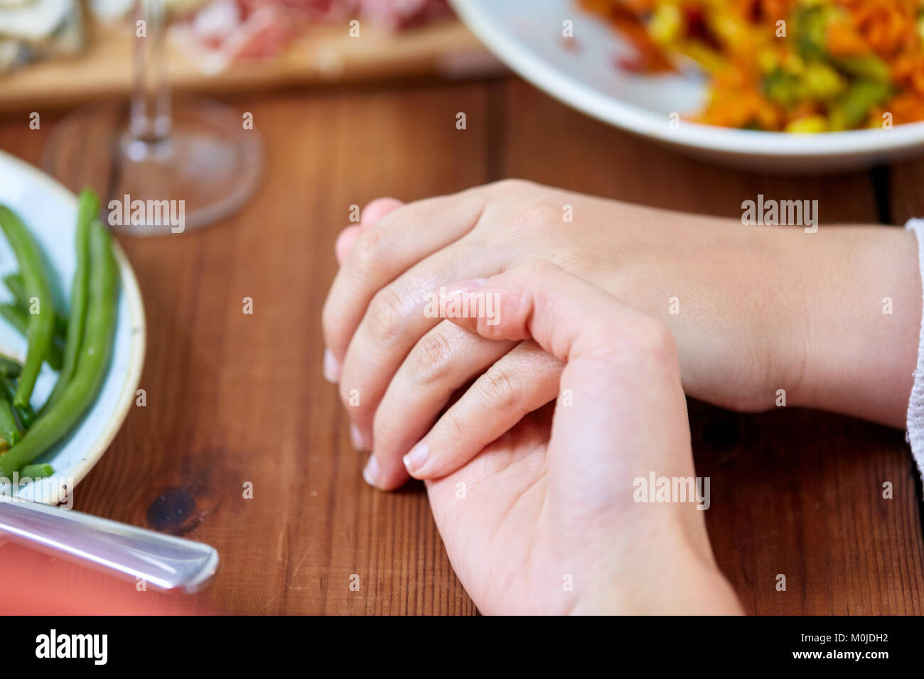 hands of people at table praying before meal Stock Photo - Alamy