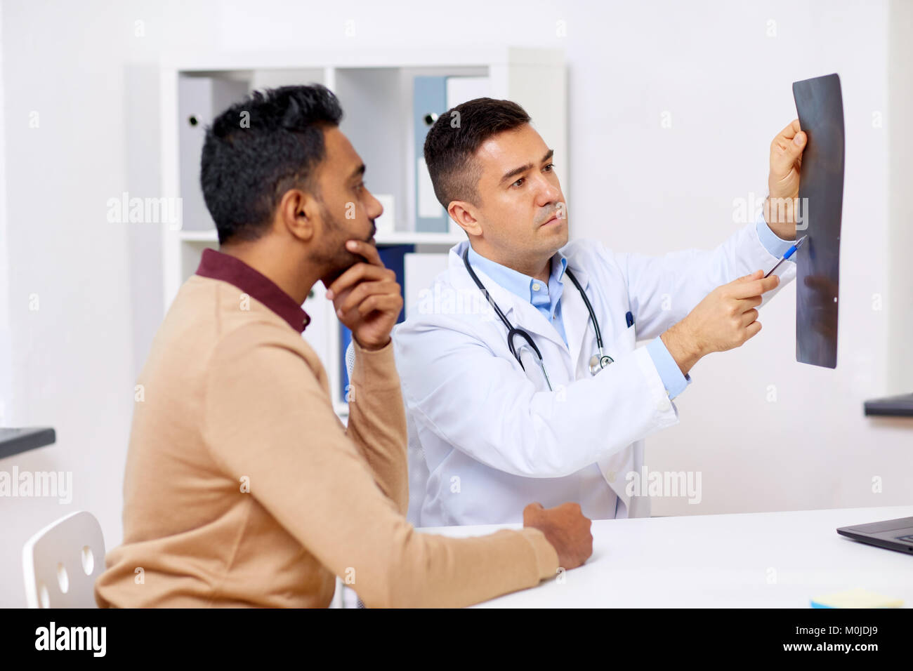 doctor with x-ray and male patient at clinic Stock Photo - Alamy