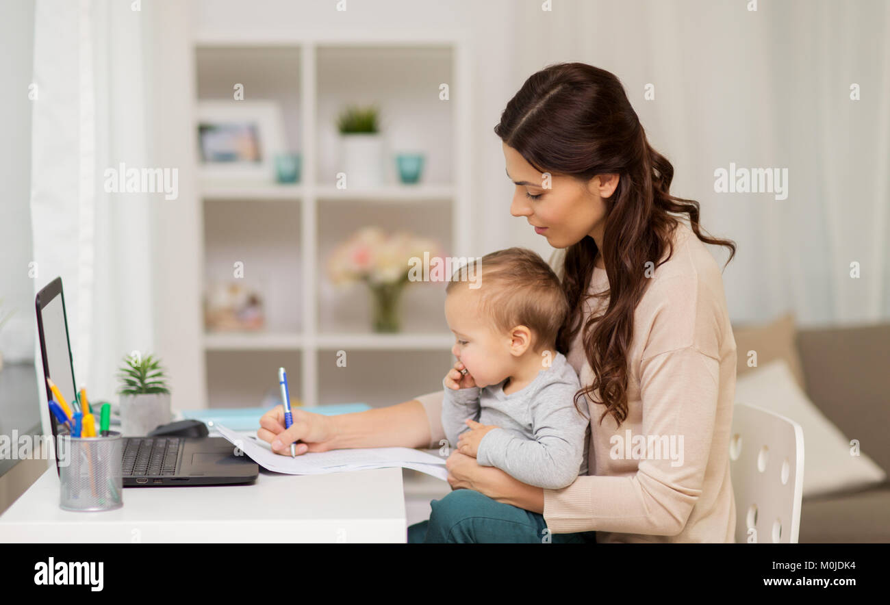 happy mother with baby and papers working at home Stock Photo - Alamy