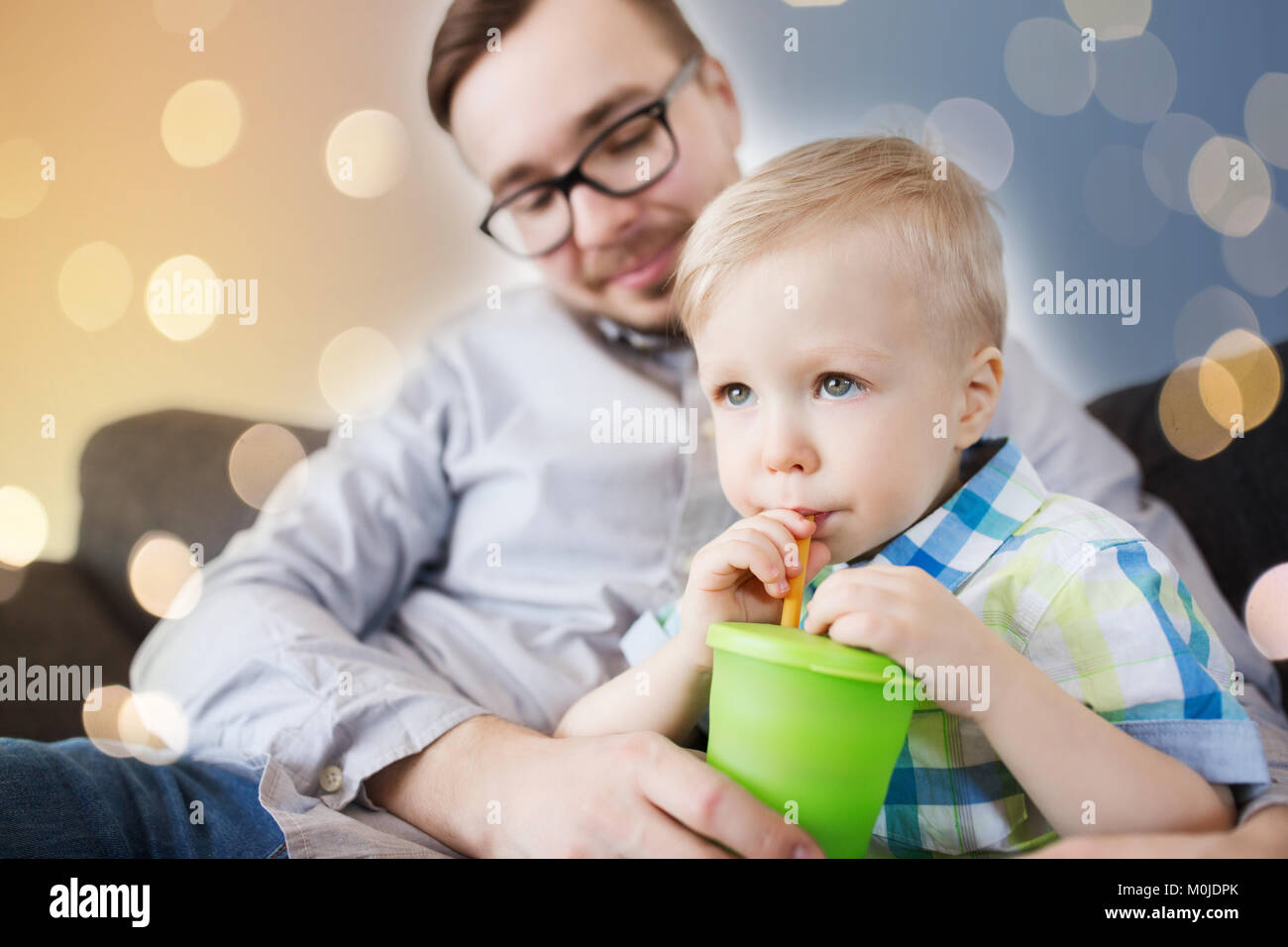 father and son drinking from cup at home Stock Photo - Alamy