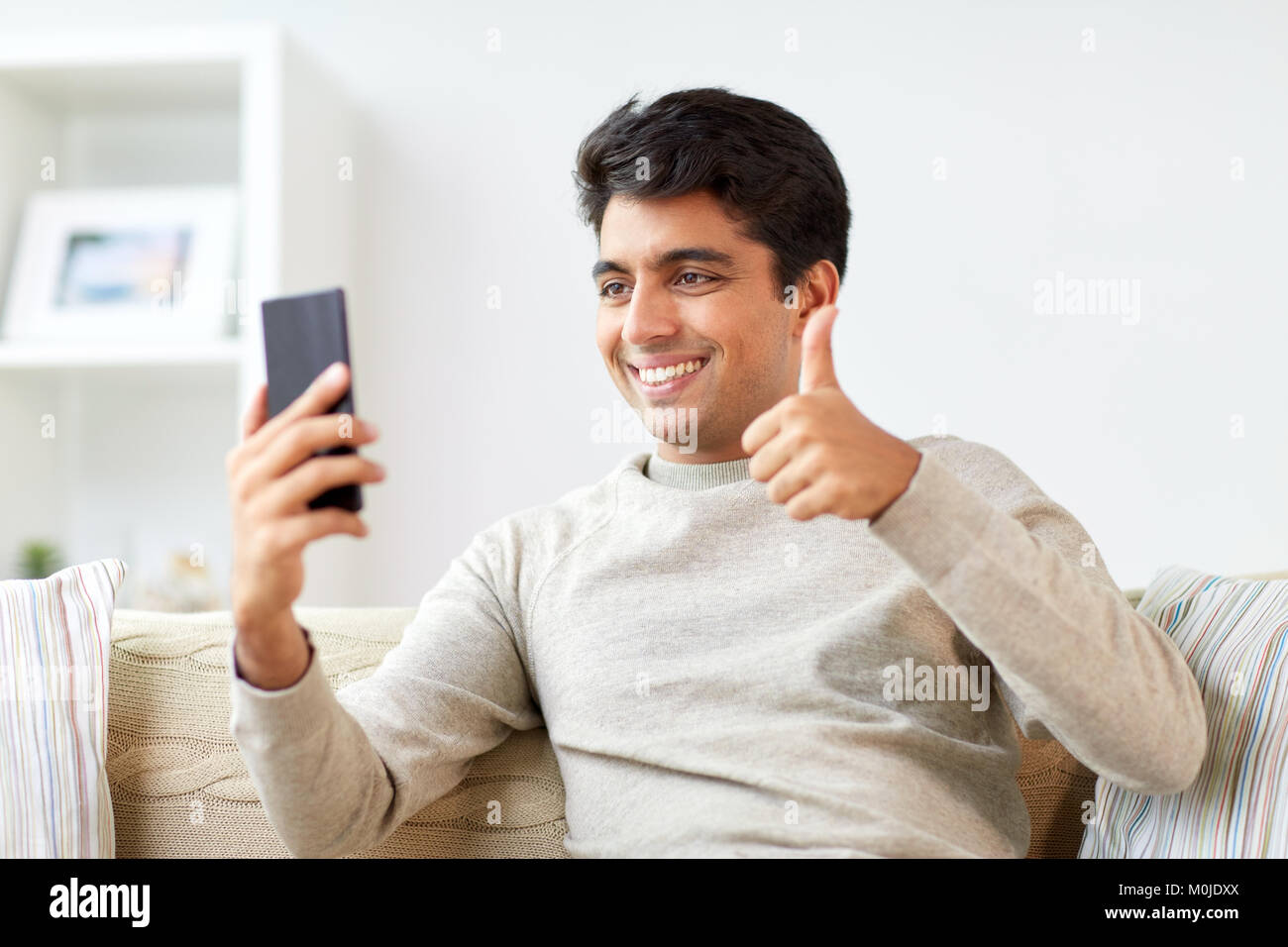 happy man having video call on smartphone at home Stock Photo - Alamy