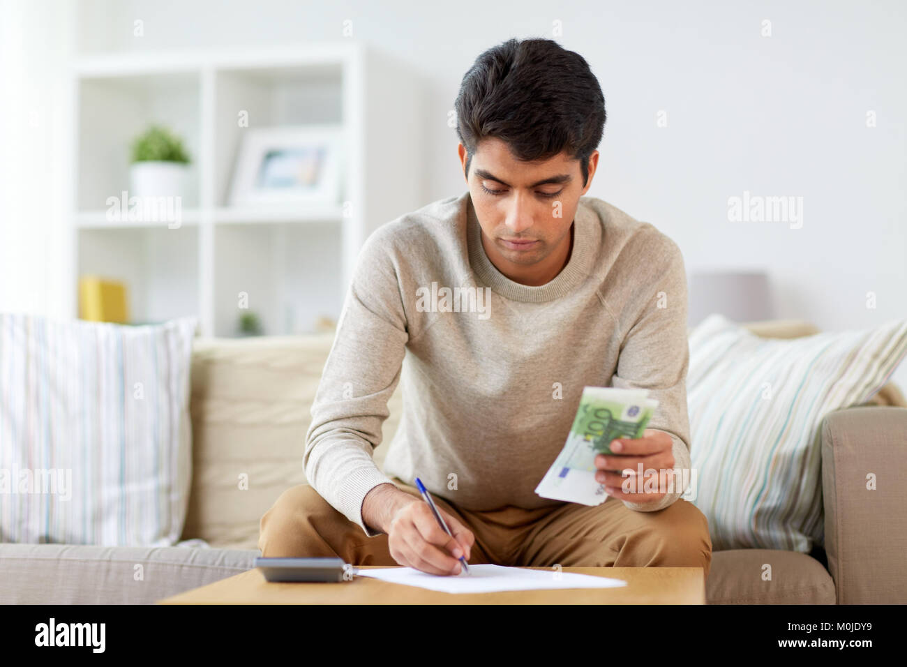 man with money and calculator filling papers Stock Photo - Alamy
