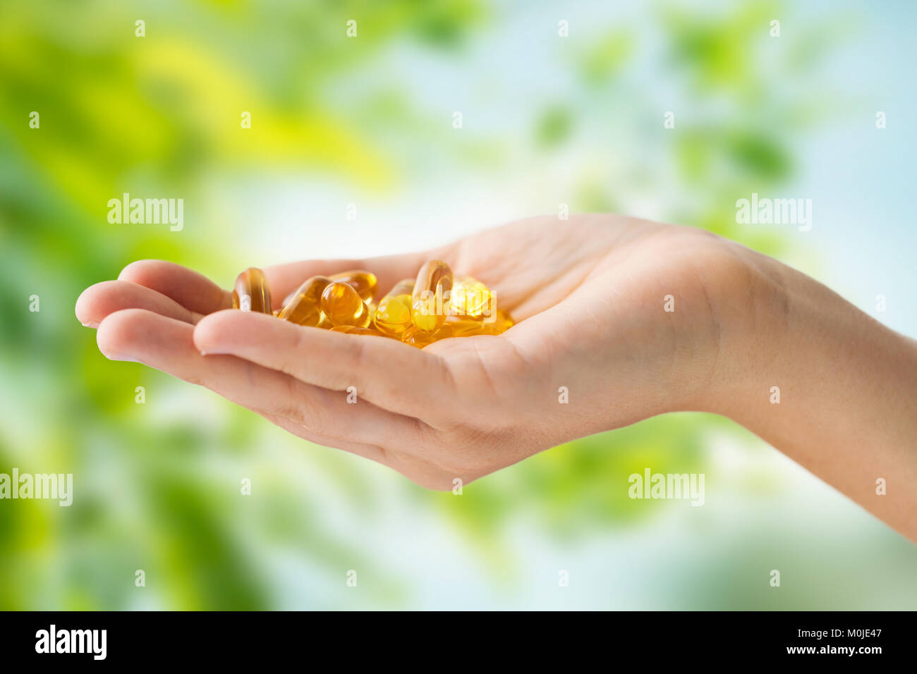 Cod liver oil capsules hand hi-res stock photography and images - Alamy