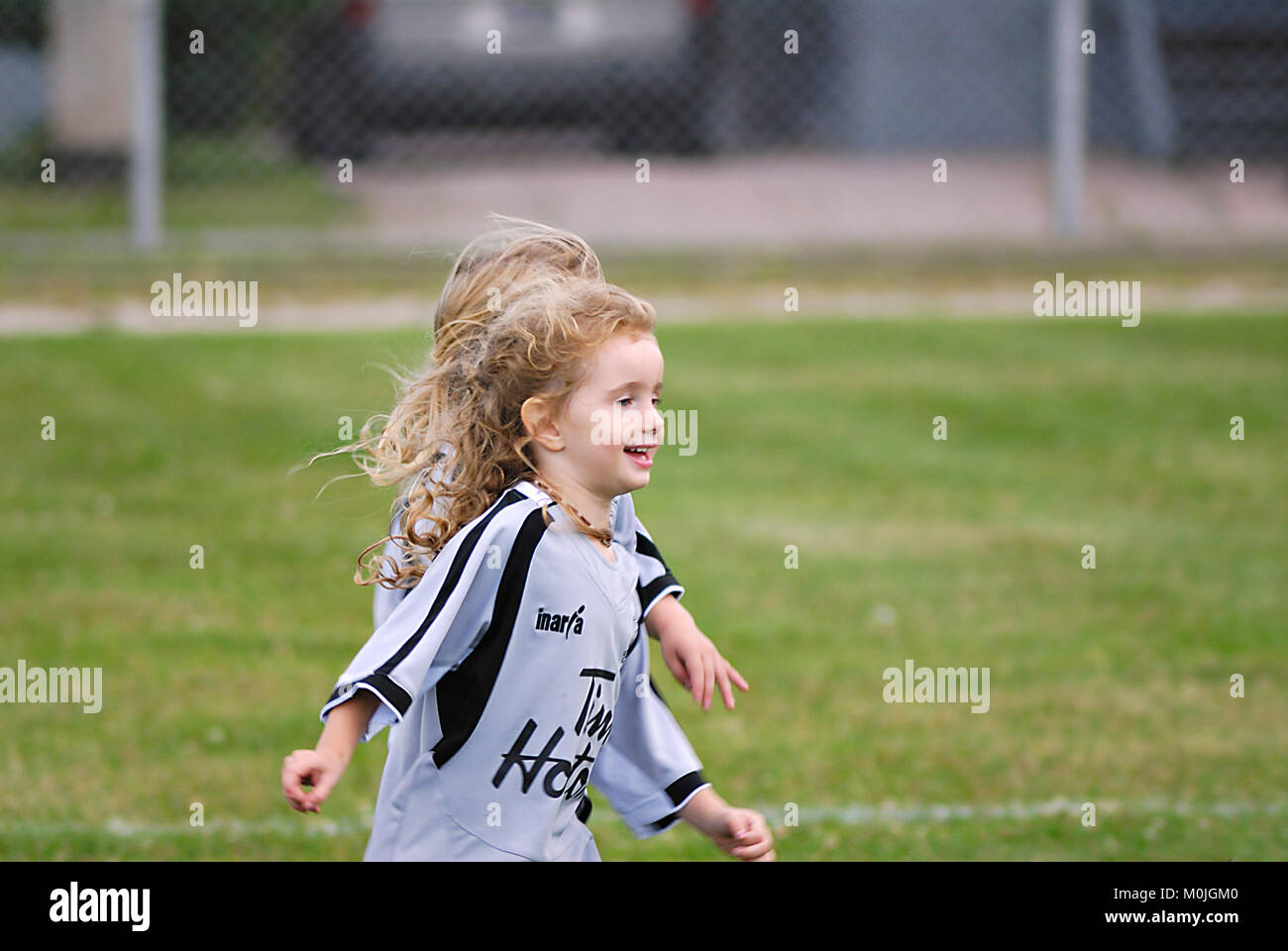 A beautiful smiling blonde girl is having fun playing soccer Stock ...
