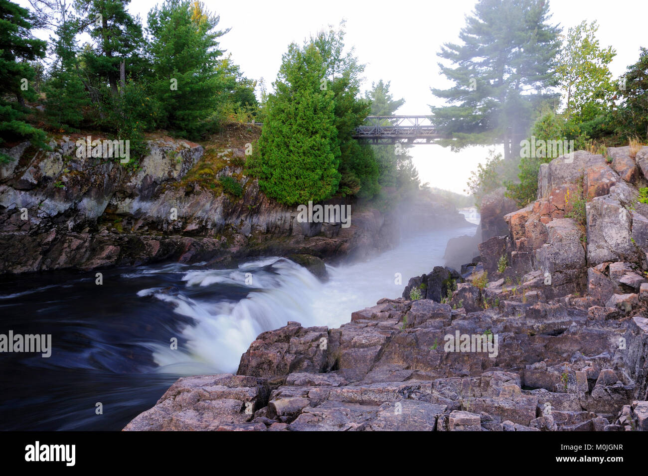 a Bailey bridge over some rapids on the upper French river Stock Photo ...