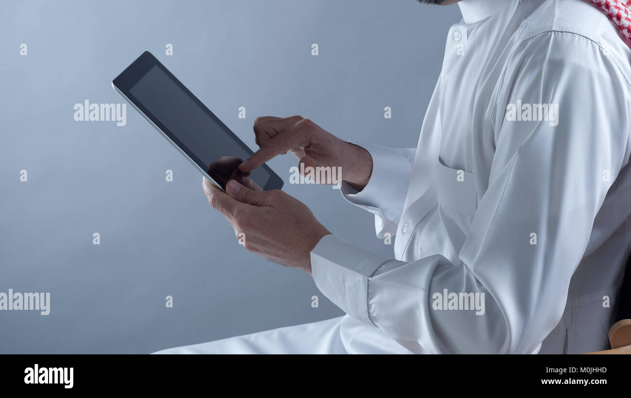 Saudi Arabian Man Hands Holding and Using Tablet Stock Photo - Alamy