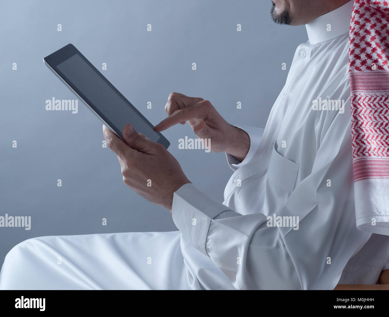 Saudi Arabian Man Hands Holding and Using Tablet Stock Photo - Alamy