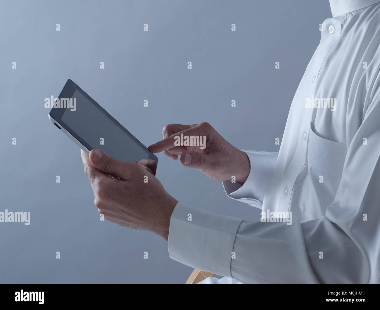 Saudi Arabian Man Hands Holding and Using Tablet Stock Photo - Alamy