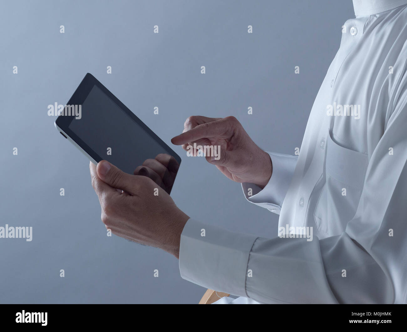 Saudi Arabian Man Hands Holding and Using Tablet Stock Photo - Alamy