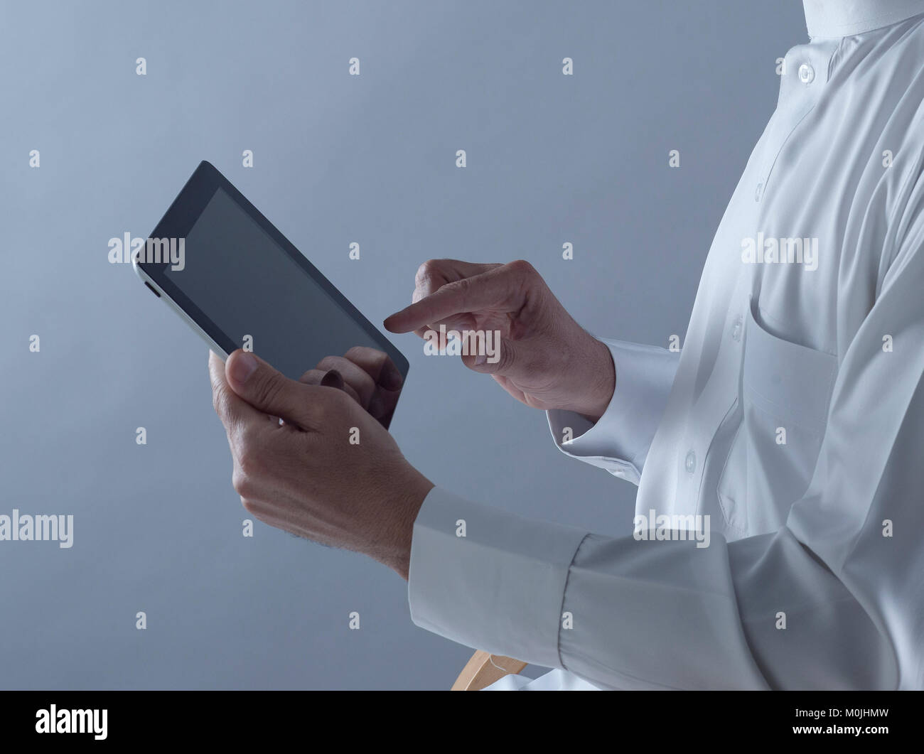 Saudi Arabian Man Hands Holding and Using Tablet Stock Photo - Alamy
