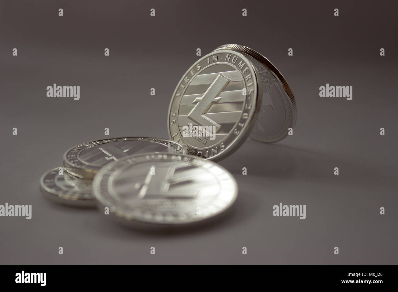 On a grey background are silver coins of a digital crypto currency ...