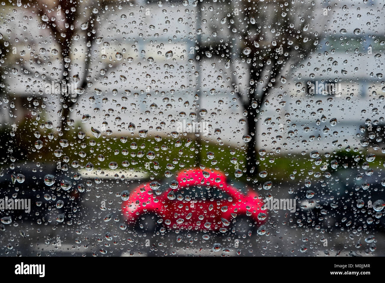 red car is seeing behind raindrops at a window glass Stock Photo - Alamy