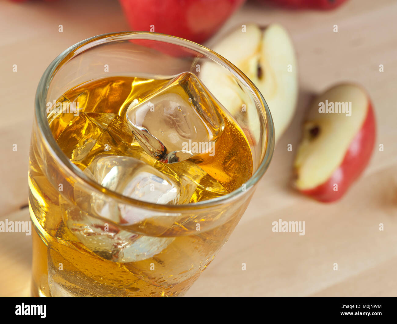 A Glass of Fresh Cold Apple Juice with Ice Beside Apples on A Wooden ...