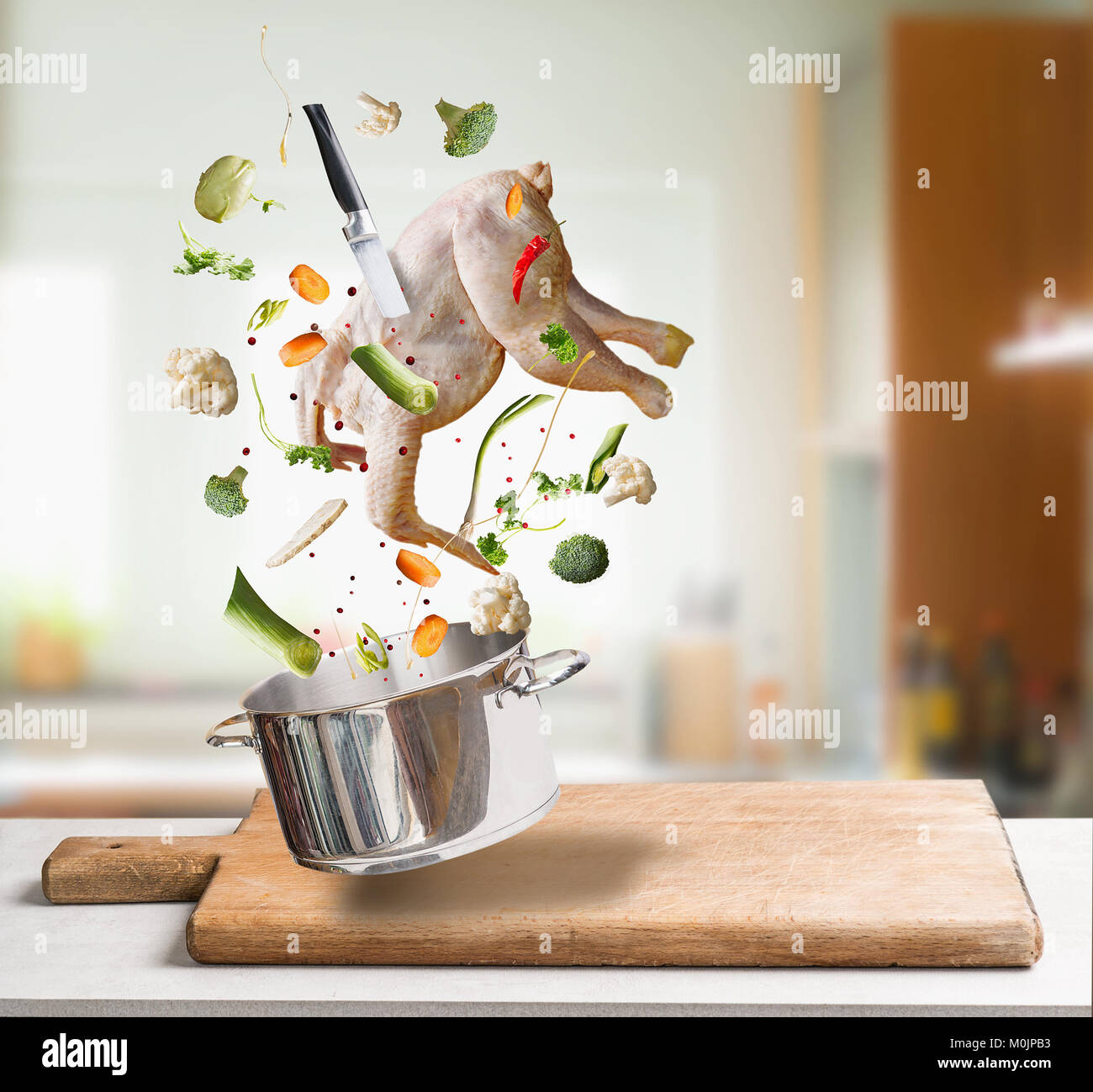 Flying raw chicken stock ,bouillon or soup ingredients with whole ...