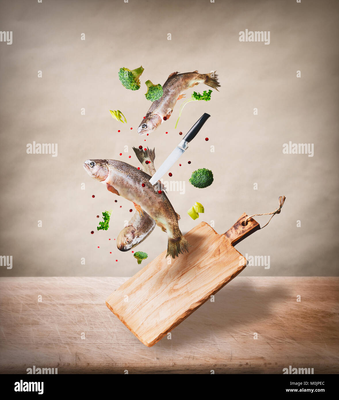 Flying raw whole trout fishes with vegetables, oil and spices ...