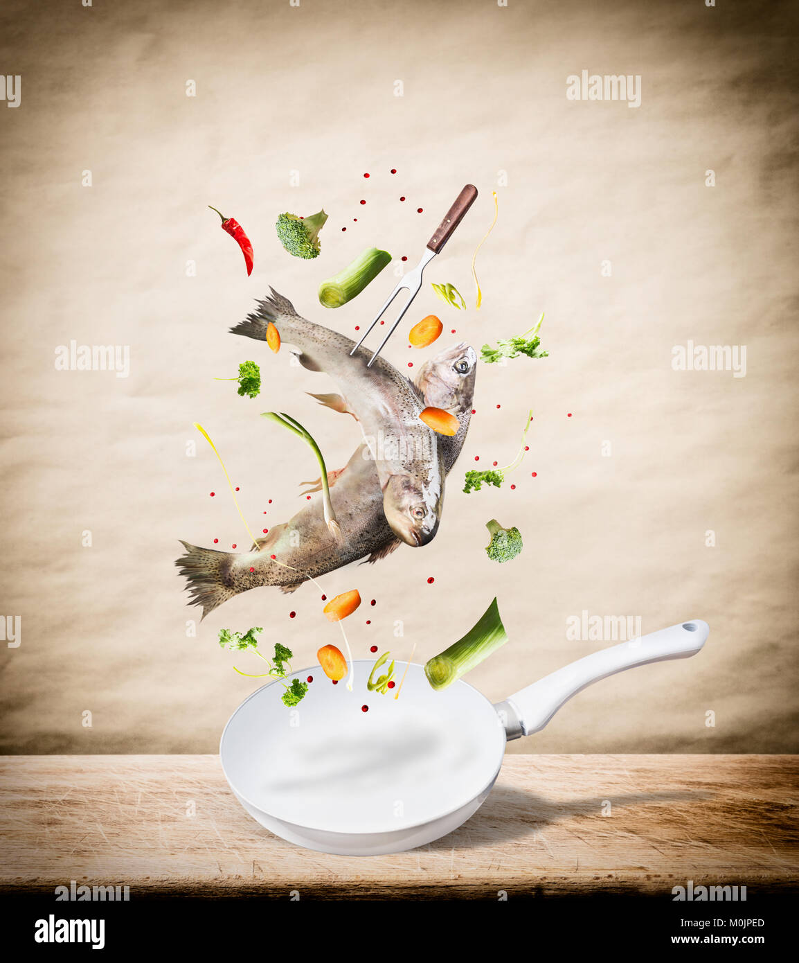 Flying raw whole trout fishes with vegetables, oil and spices ...