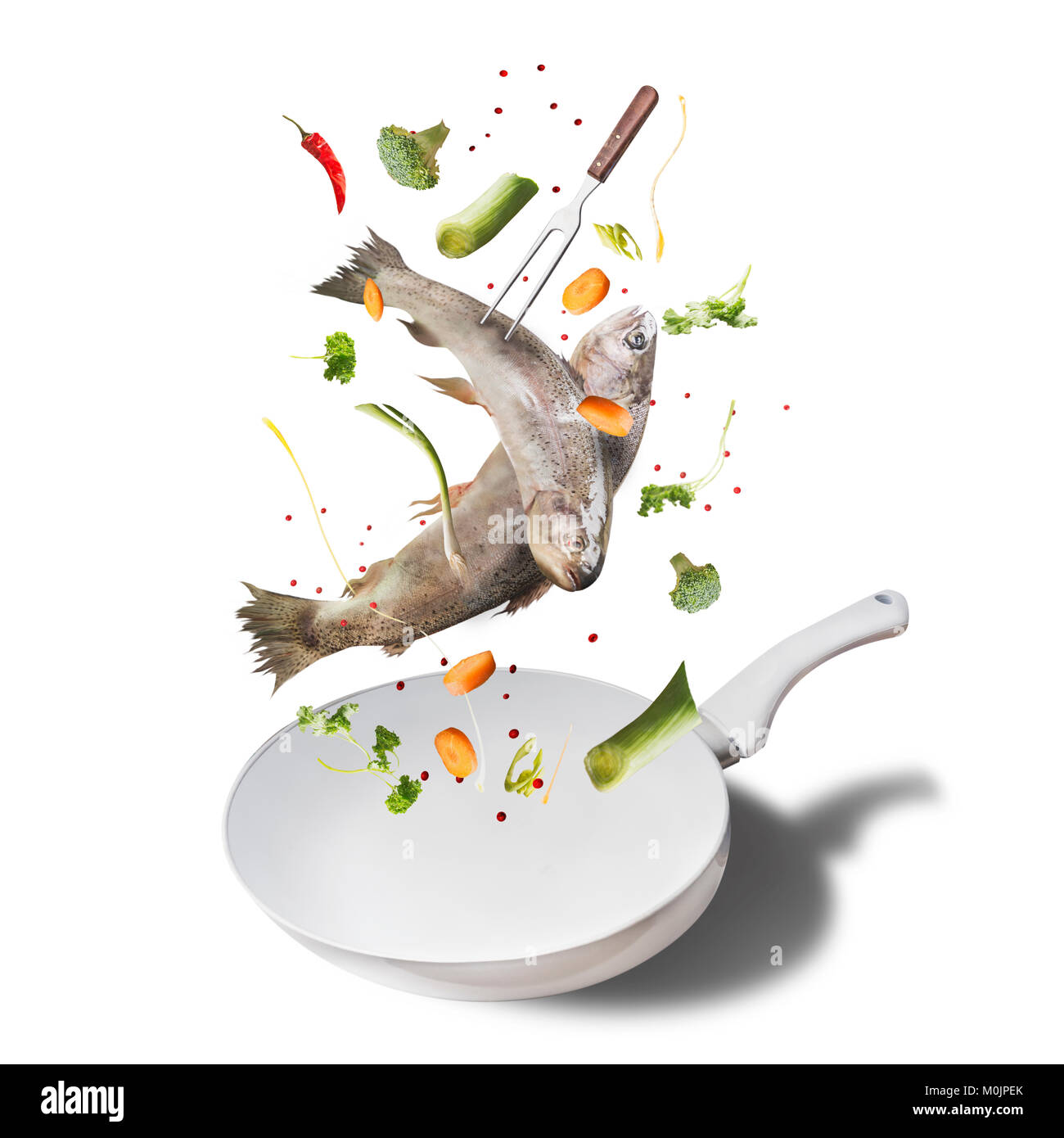 Flying raw whole trout fishes with vegetables, oil and spices ...