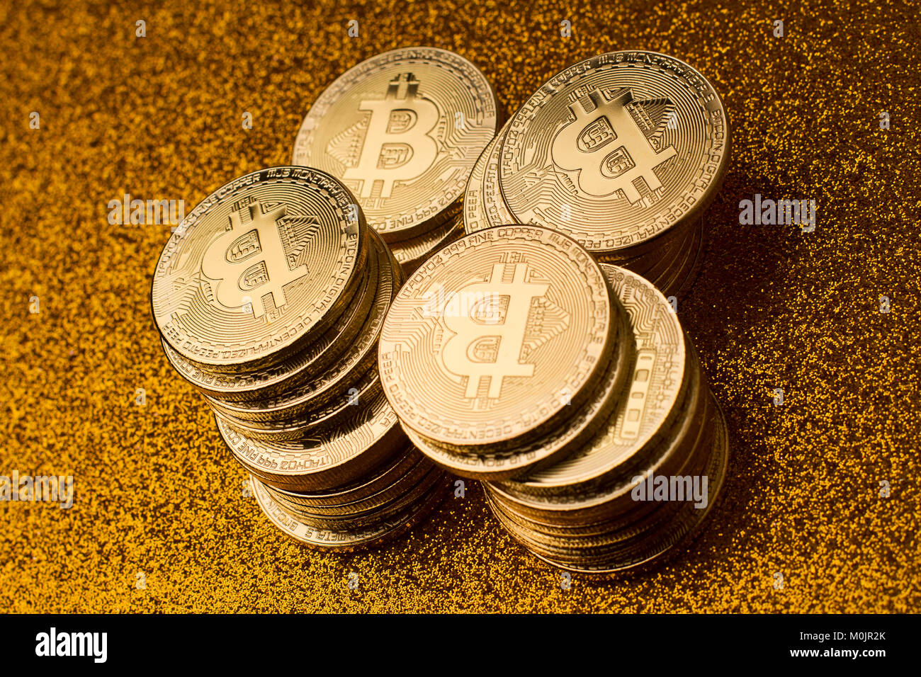 horizontal top view of stacks of bitcoin coins on golden glittering ...