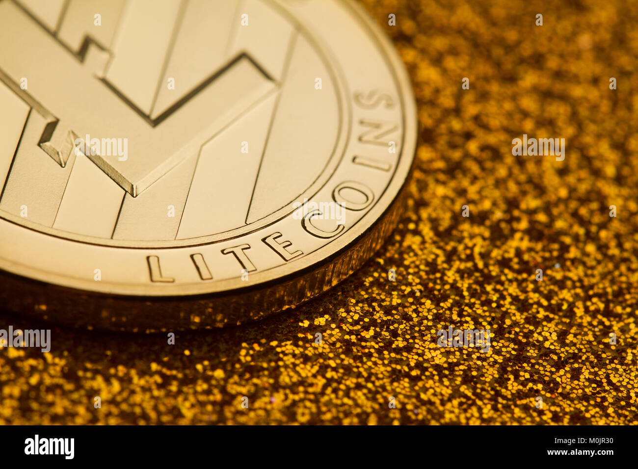 horizontal top view detail closeup of single litecoin coin on golden ...