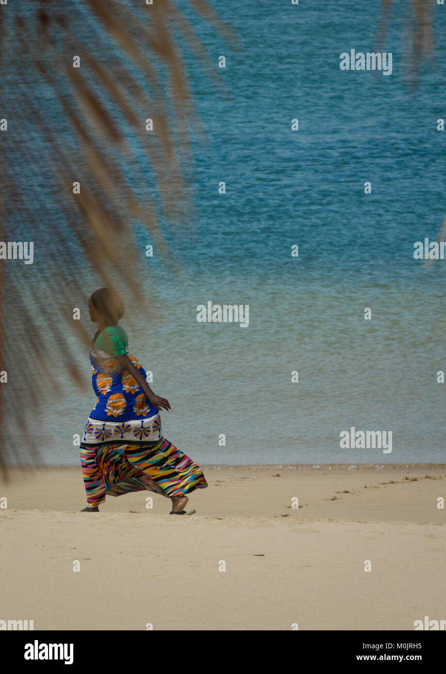 Woman with colorful kaftan crossing Kizingoni beach, Lamu, Kenya Stock ...