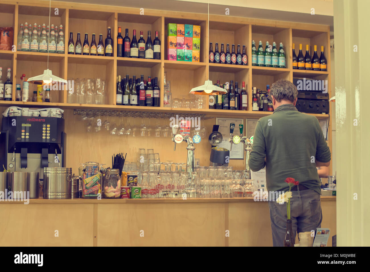 Man at restaurant counter waiting to pay Stock Photo - Alamy