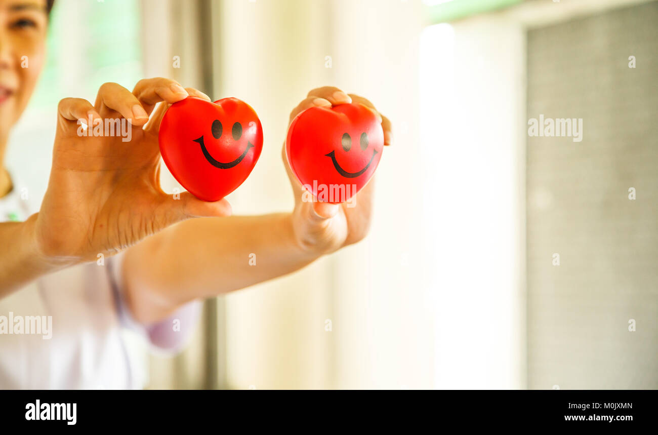 Two Red Smiling Hearts held by female nurse's hands, representing ...