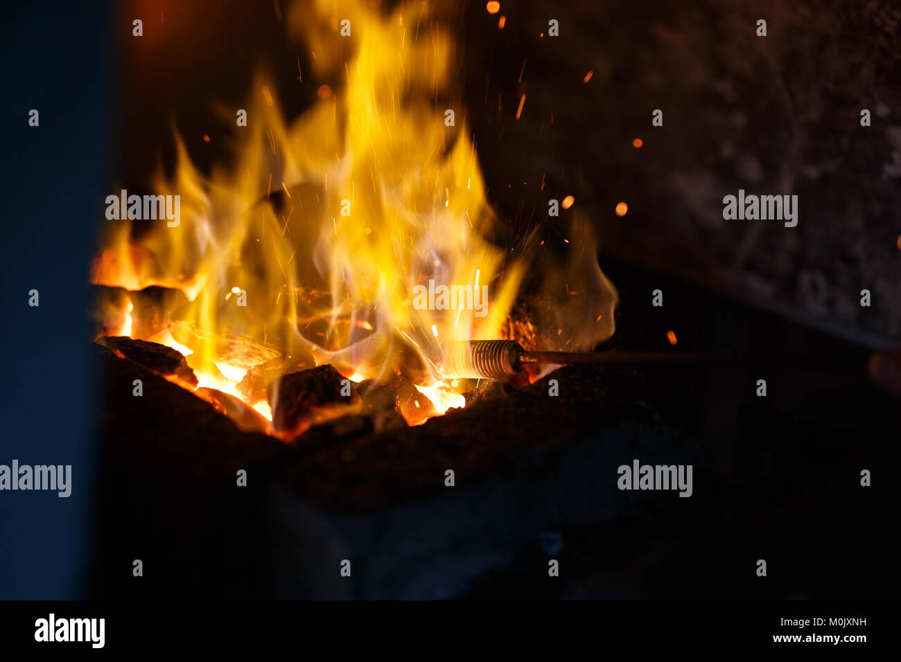 Hot metal in the fire before being hammered by a blacksmith Stock Photo ...