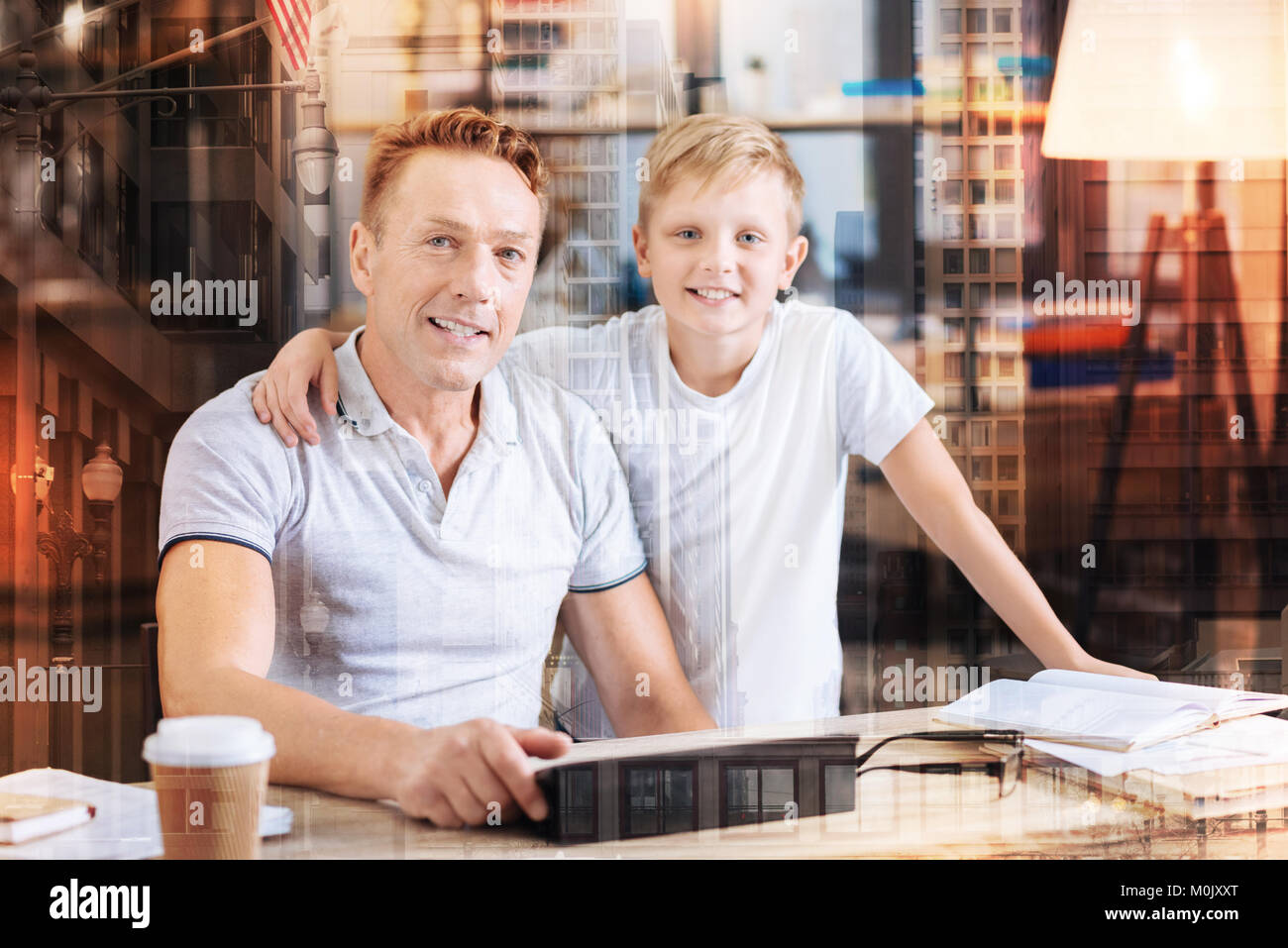 Friendly father and son standing against urban surrounding Stock Photo ...